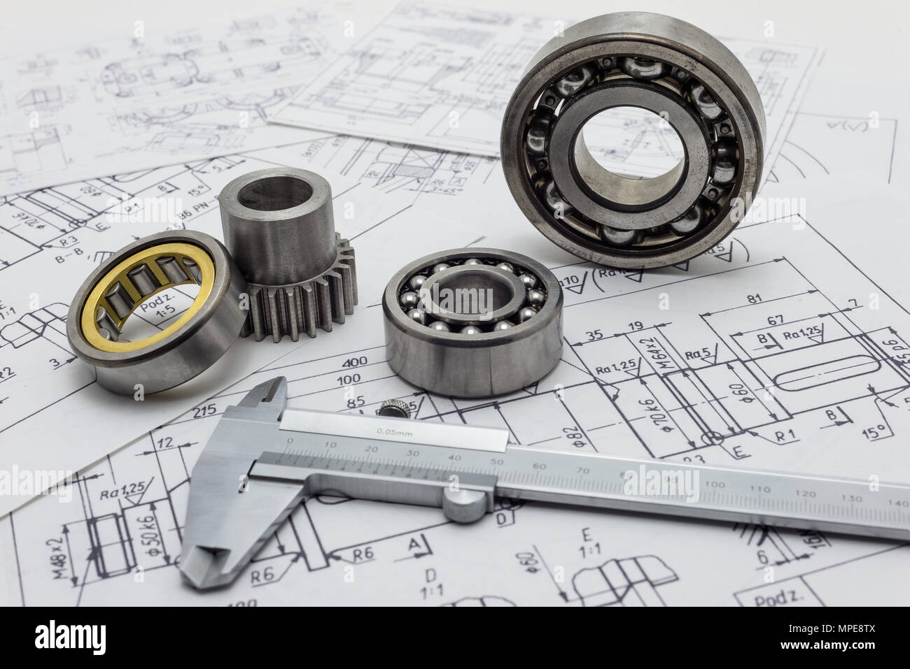 Vernier caliper lying on mechanical scheme with bearing and small gear ...