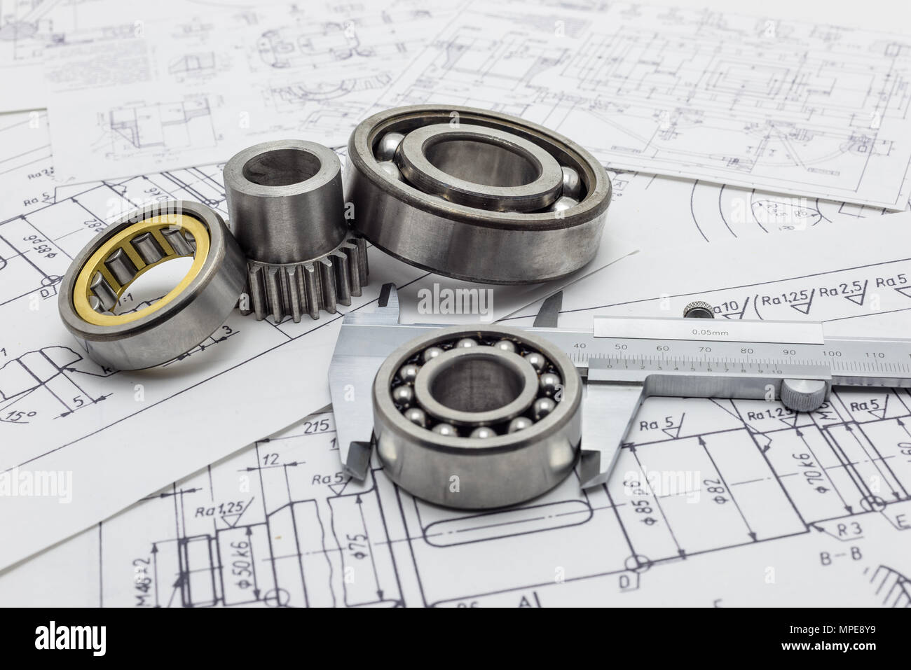 Vernier caliper lying on mechanical scheme with bearing and small gear ...