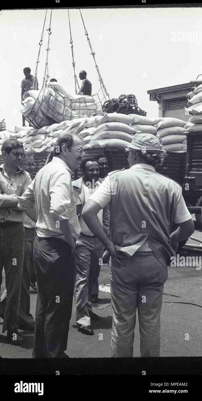 A GROUP OF WORKING MEN STANDING AROUND HAVING A CONVERSATION Stock ...