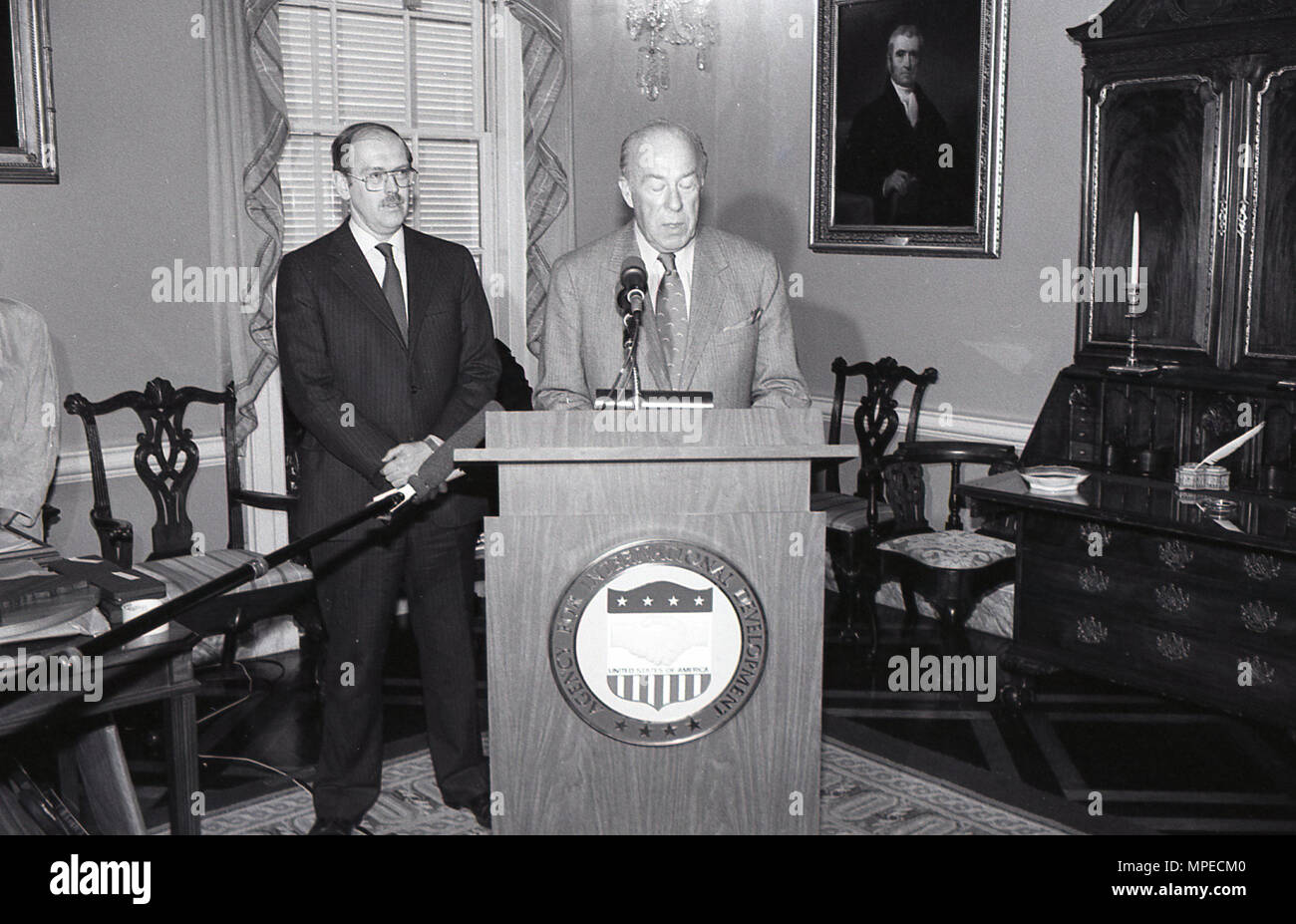 MAN AT THE PODIUM GIVING A SPEECH WITH A MAN STANDING NEXT TO HIM Stock ...