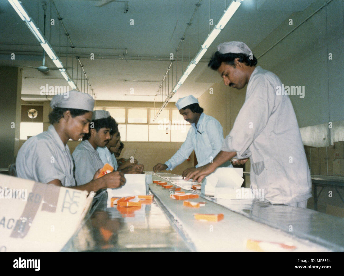 A GROUP OF MEN AND WOMEN WORKING ON THE LINE AT THE WOODWARD FACTORY ...