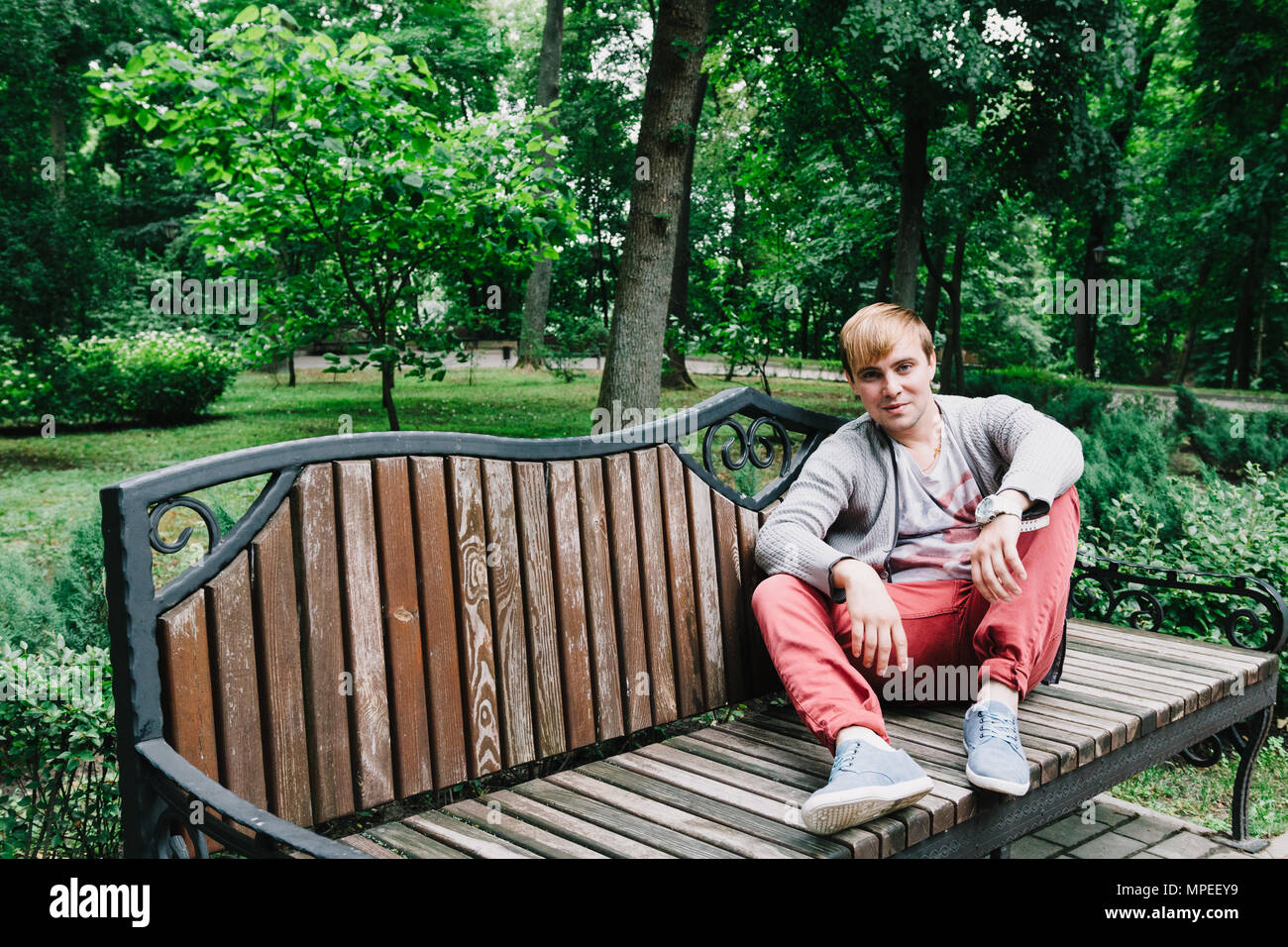 Portrait of a stylish man on a bench in the park Stock Photo - Alamy
