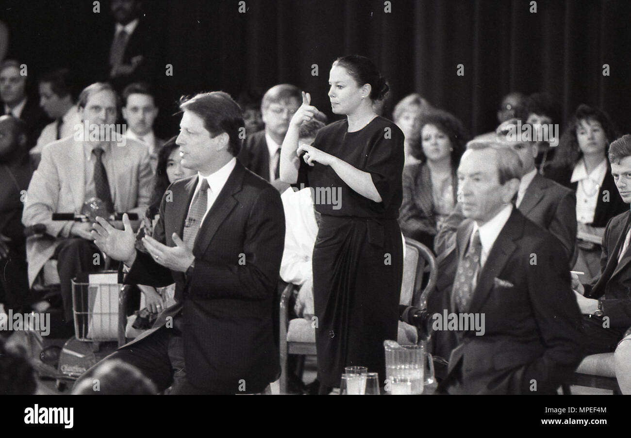 MAN TALKING TO CROWD AND WOMAN DOING SIGN LANGUAGE BEHIND HIM Stock ...