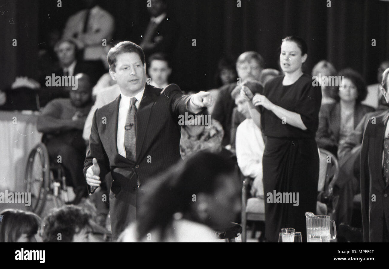 MAN TALKING TO CROWD AND WOMAN DOING SIGN LANGUAGE BEHIND HIM Stock ...