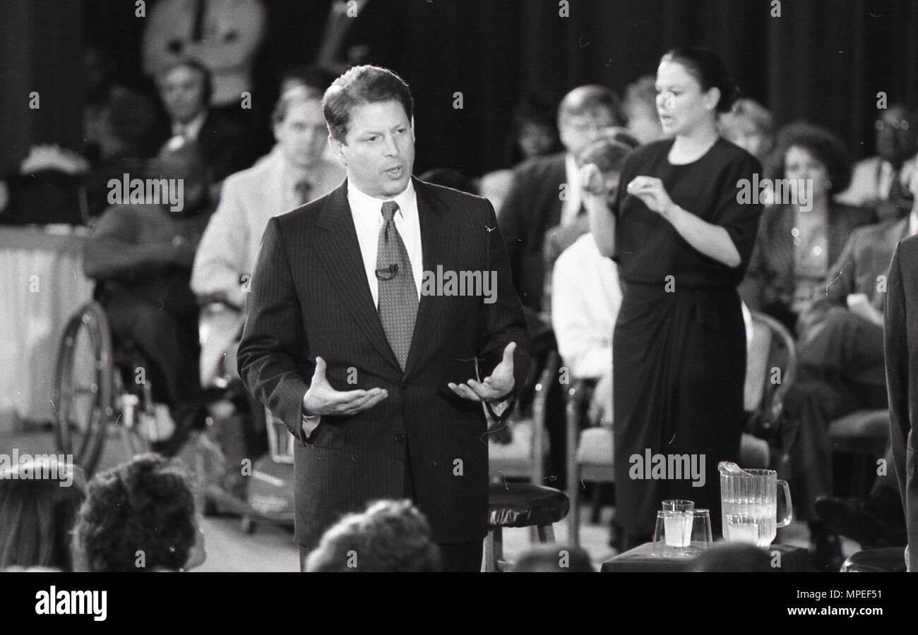 MAN TALKING TO CROWD AND WOMAN DOING SIGN LANGUAGE BEHIND HIM Stock ...