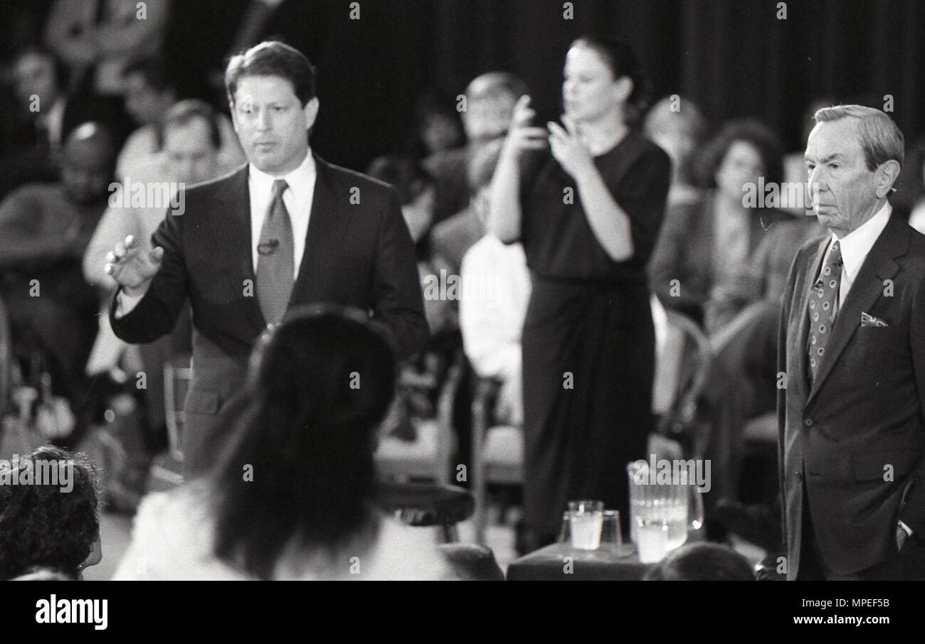 MAN TALKING TO CROWD AND WOMAN DOING SIGN LANGUAGE BEHIND HIM Stock ...
