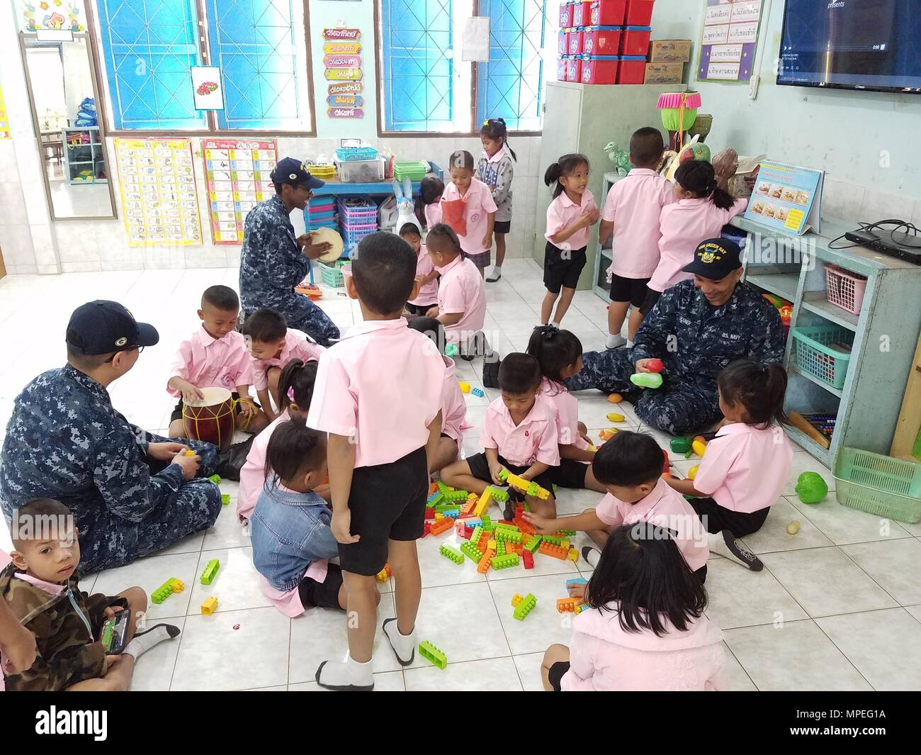 U.S. Sailors from the U.S.S. Green Bay play with children while ...