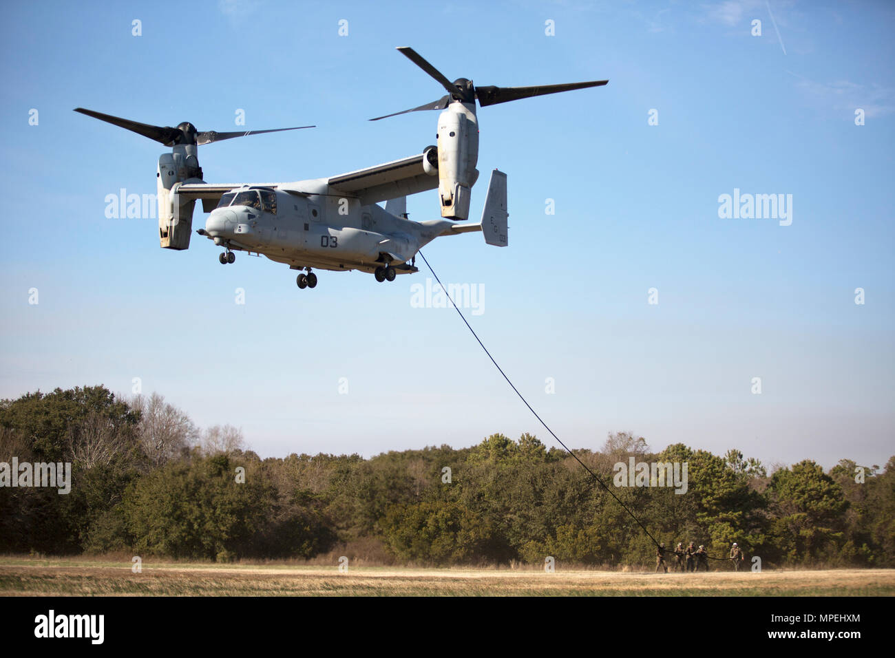 Marines stabilize a rope out of a MV-22B Osprey as it lands at Camp ...