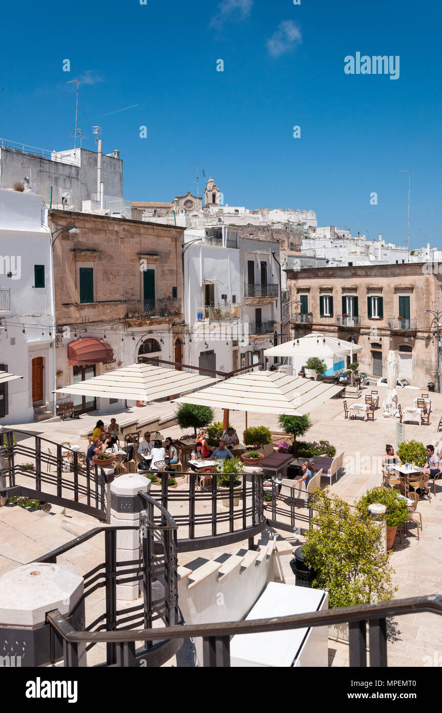 Tourists dining al fresco at a restaurant in Ostuni, Puglia, Italy ...