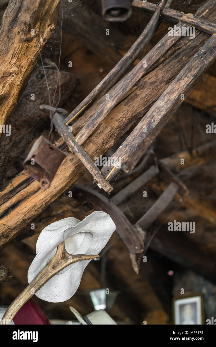 Detail closeup of an old white hat hanging from a wooden twig in an old ...