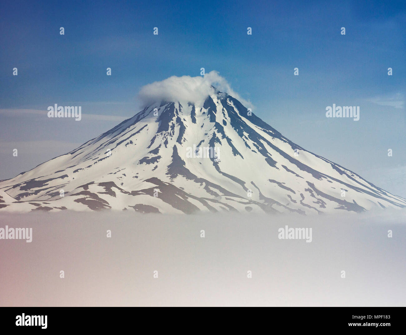 Vilyuchinsk volcano covered by snow with clouds below Stock Photo - Alamy