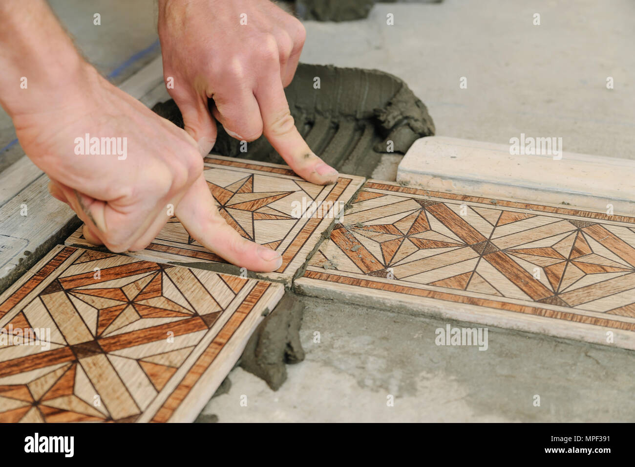 Installing ceramic floor tiles placing hi-res stock photography and ...