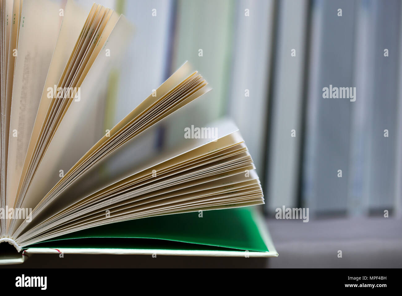 Open book, stack of hardback books on table. Top view Stock Photo - Alamy