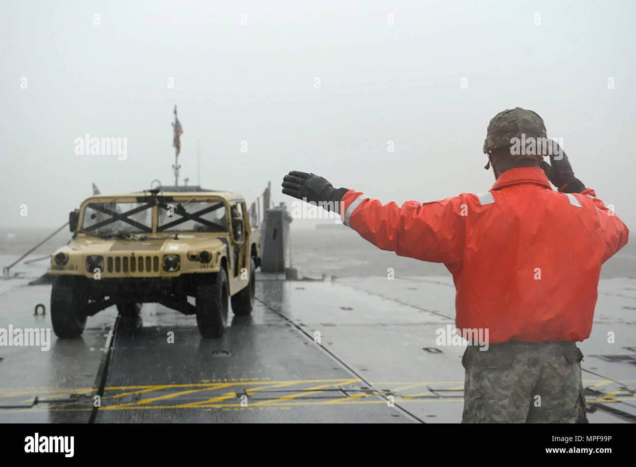 A U.S. Army Soldier directs a Humvee onto a LMC-8 Mike boat during a ...