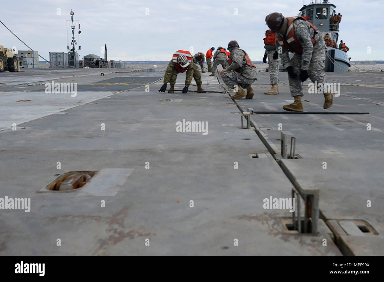 U.S. Army Soldiers disassemble the floating causeway after a sling-load ...