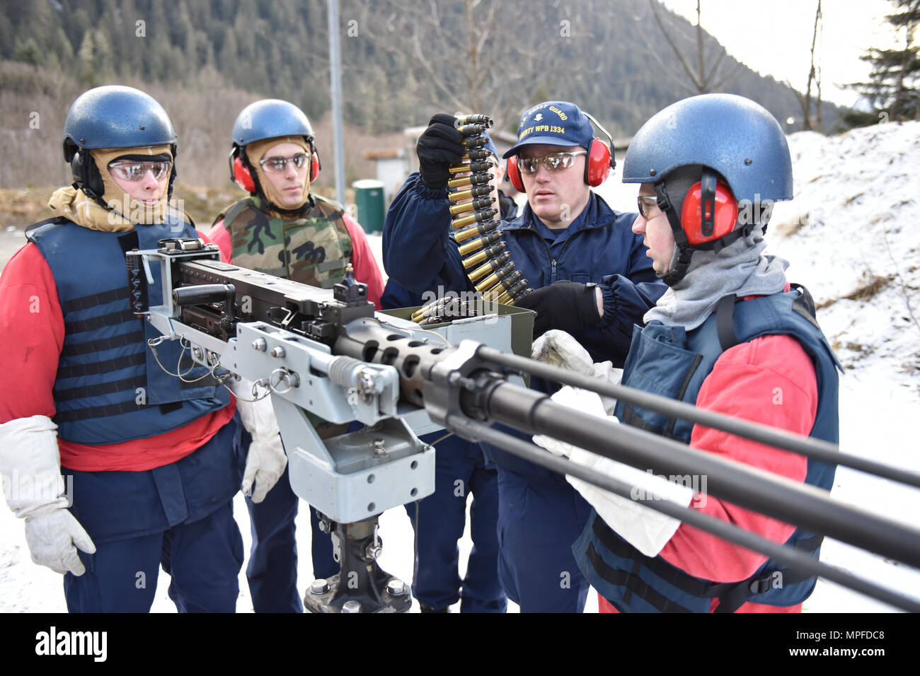 Crewmembers from the Coast Guard Cutter Liberty load a .50 caliber ...