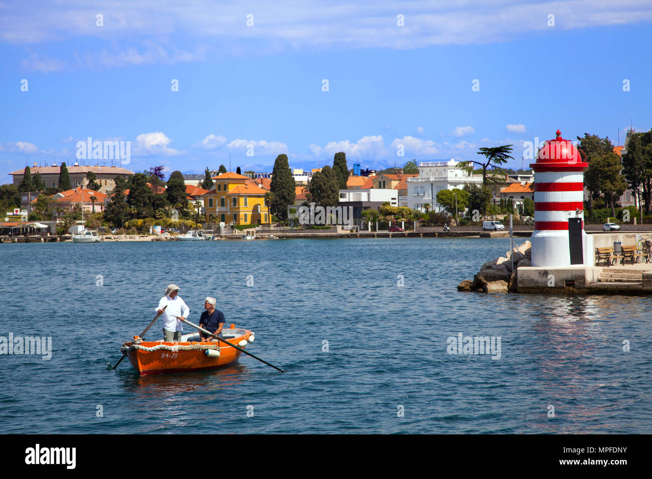 Ferryman rowing tourists and holidaymakers across the Jazine harbour in ...