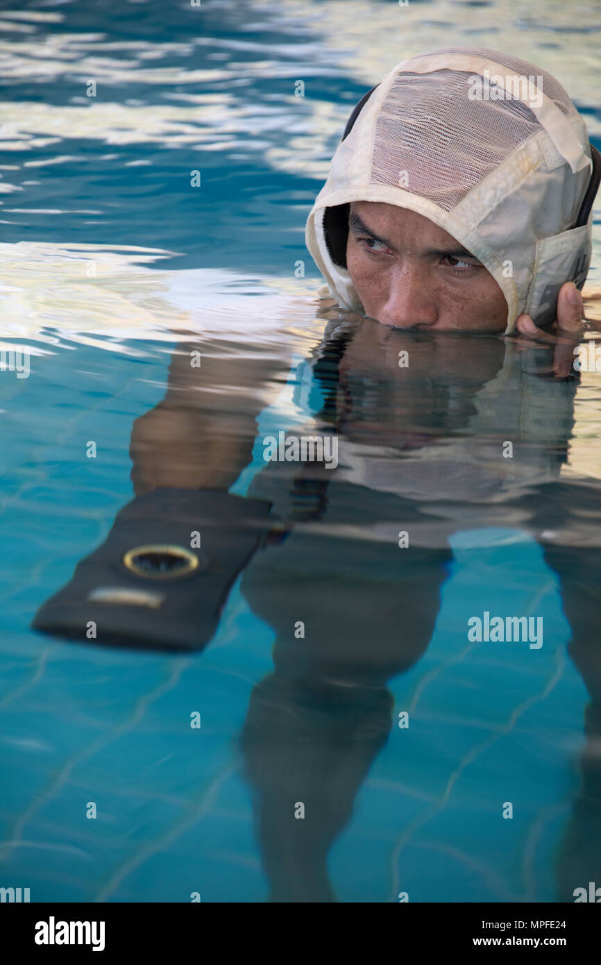 A Royal Thai Navy diver practices using hand-held sonar in a pool at ...