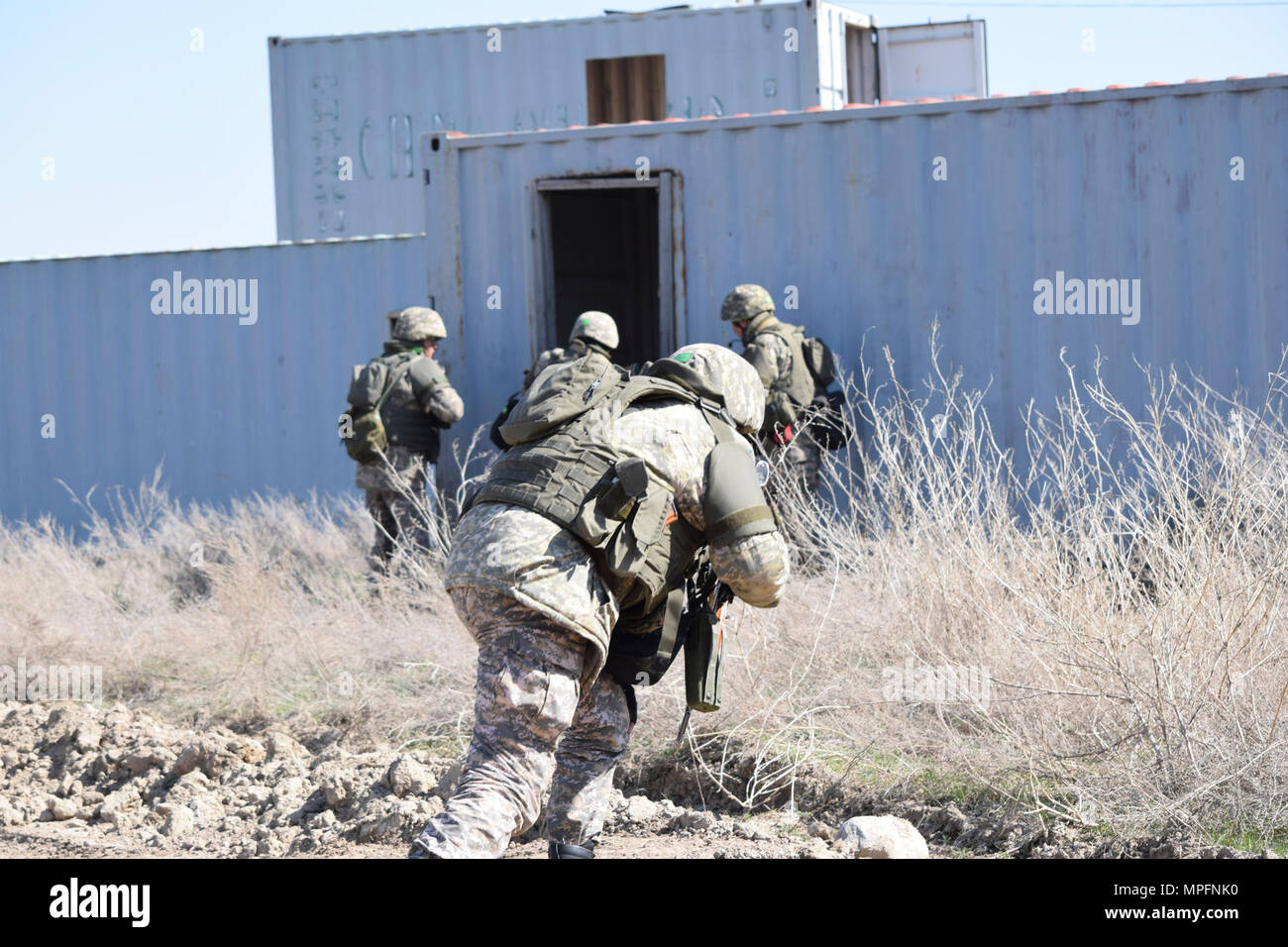 A Kazakhstani soldier runs toward cover during a cordon and search ...
