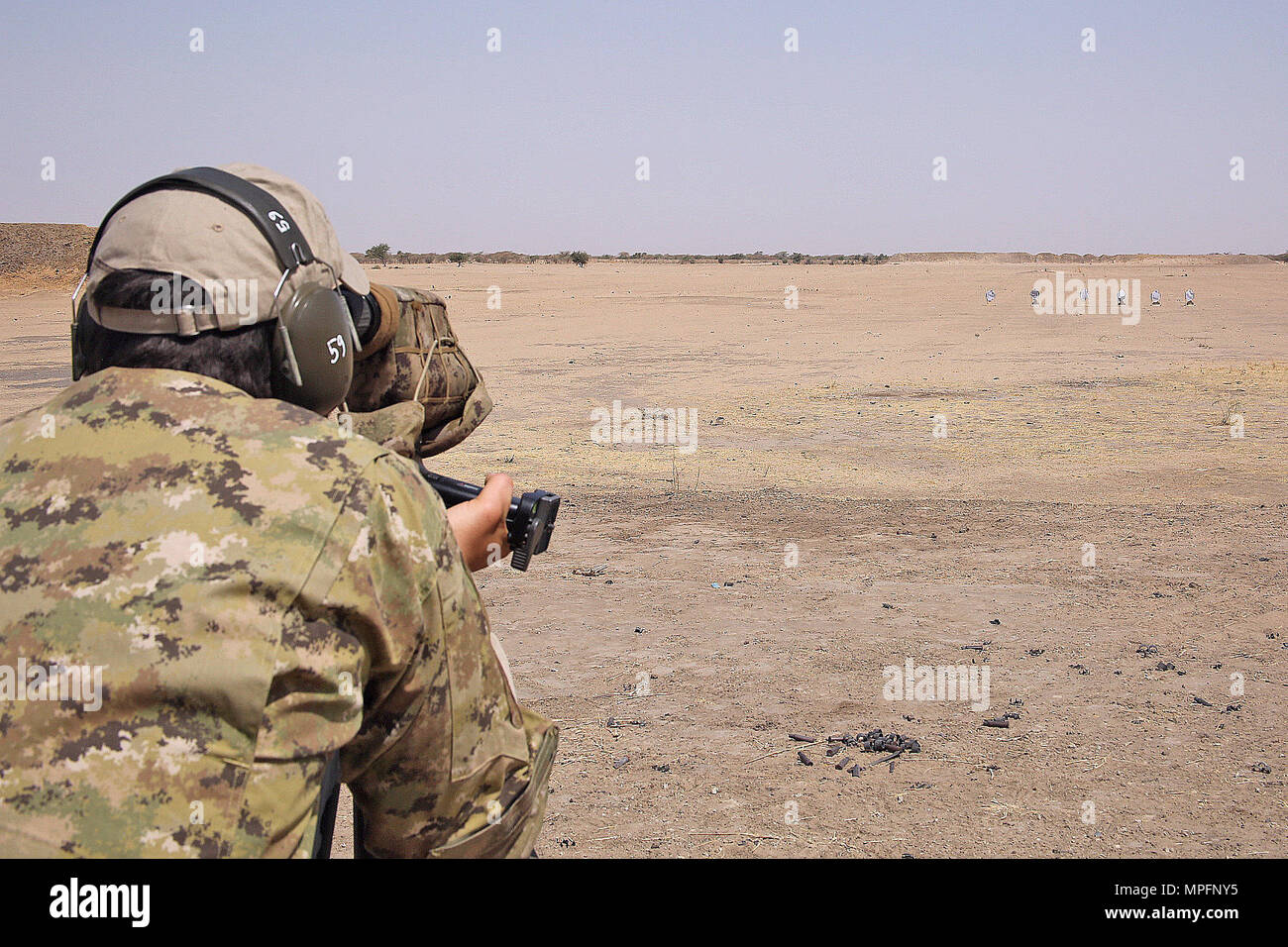 An Italian Special Forces soldier uses a spotting scope to mark a ...