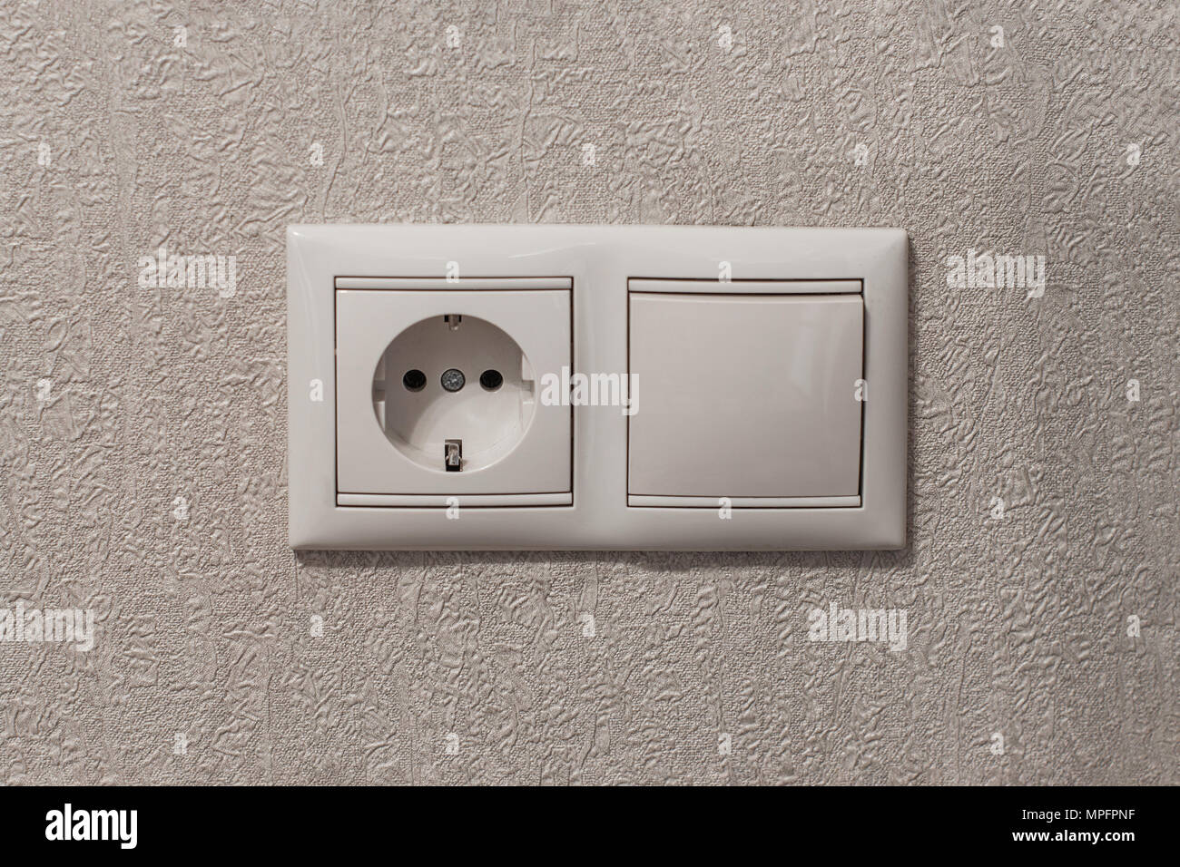 Socket and switch on beige wall close-up Stock Photo - Alamy