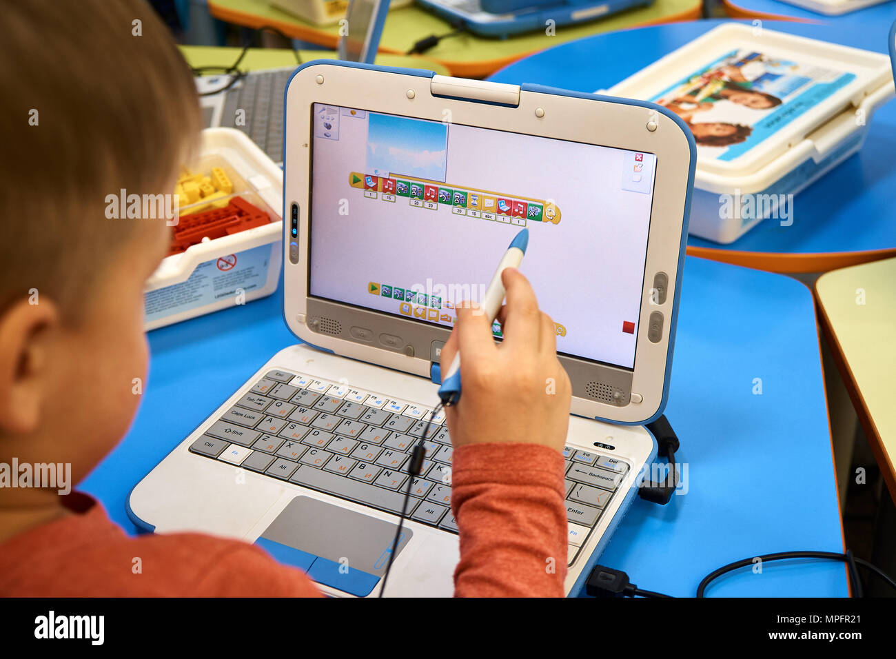 Kid learns how to code. Little boy working on laptop with stylus Stock ...