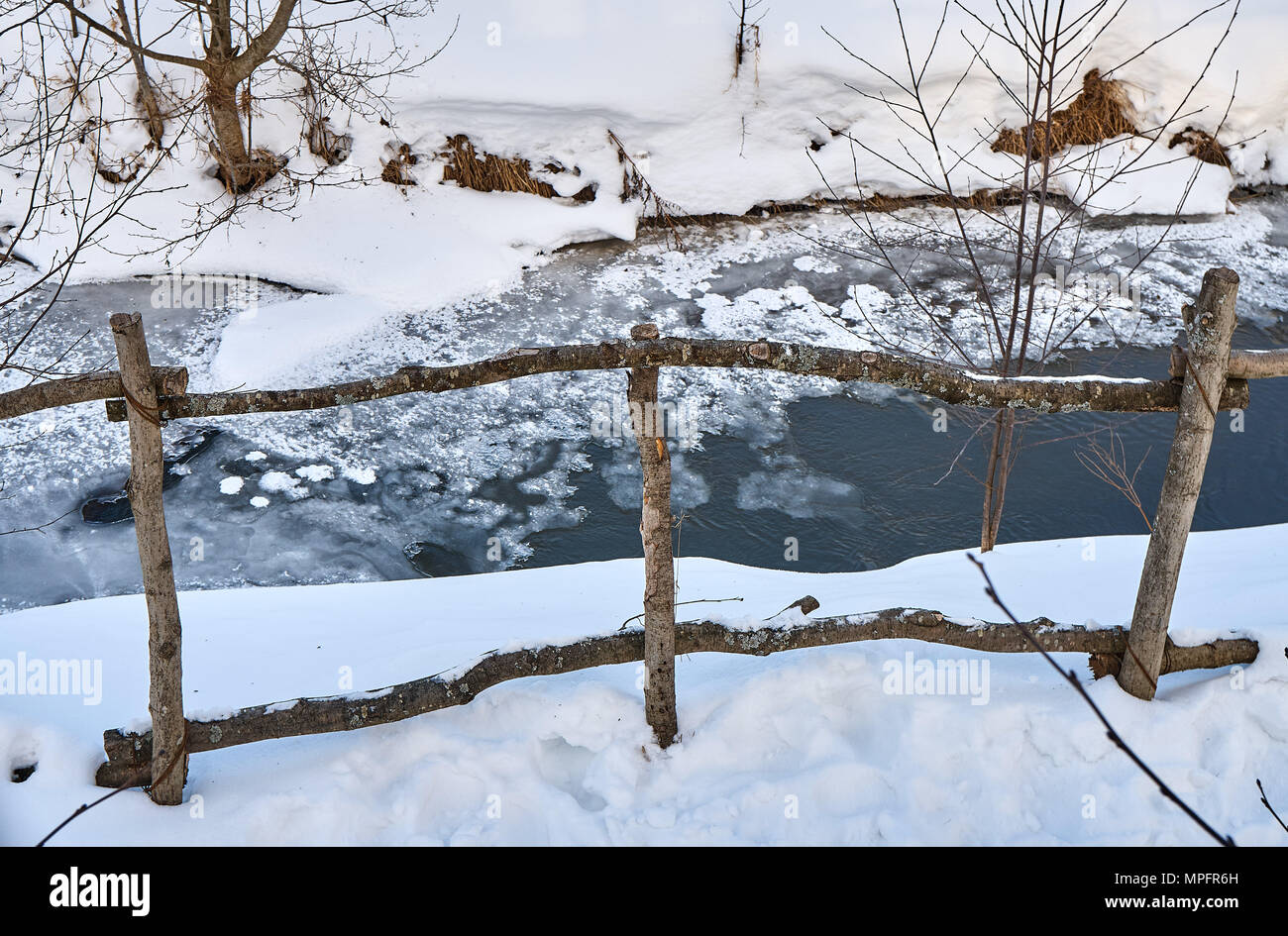 Wooden fence made of old dry thin logs. Stream fence. Rural scene, view ...