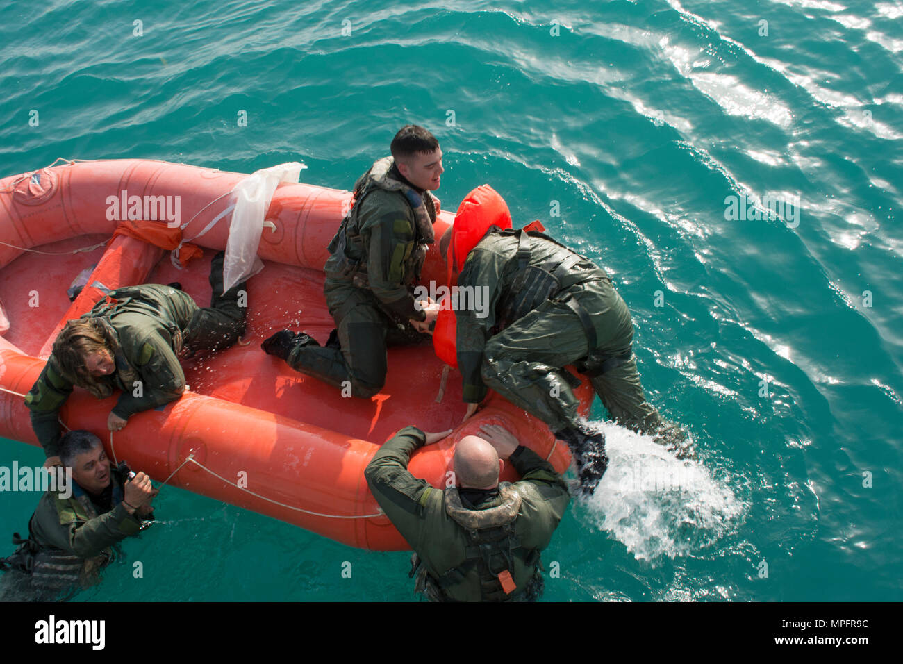 Kuwait- Soldiers climb aboard a survival raft to await rescue from the ...