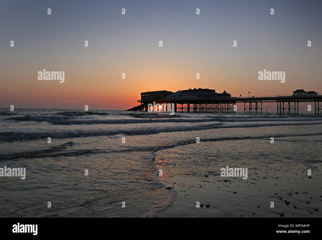The sun rises behind cromer pier hi-res stock photography and images ...