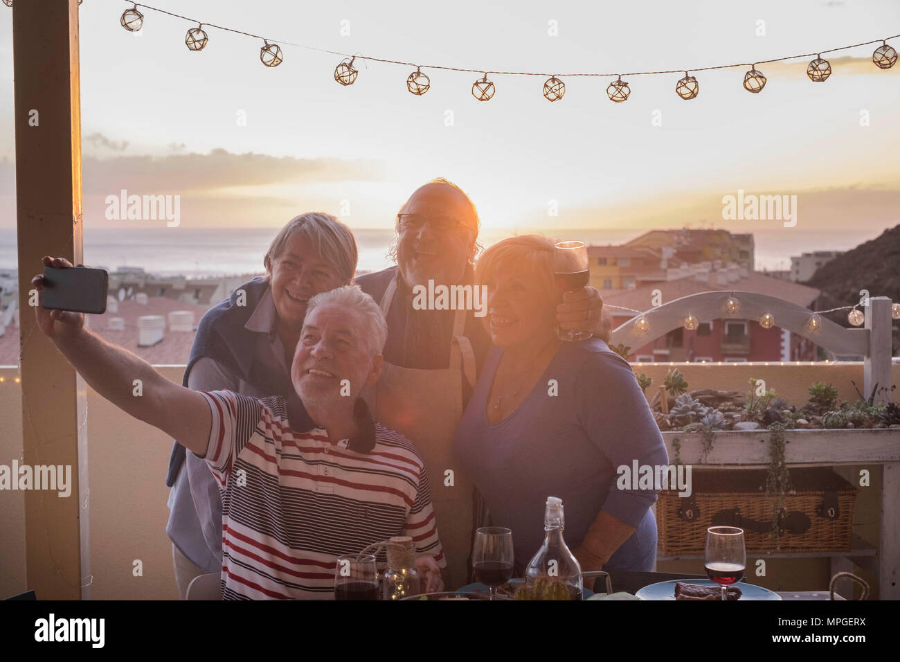Group of four people friends enjoying food on the terrace field. Bright ...