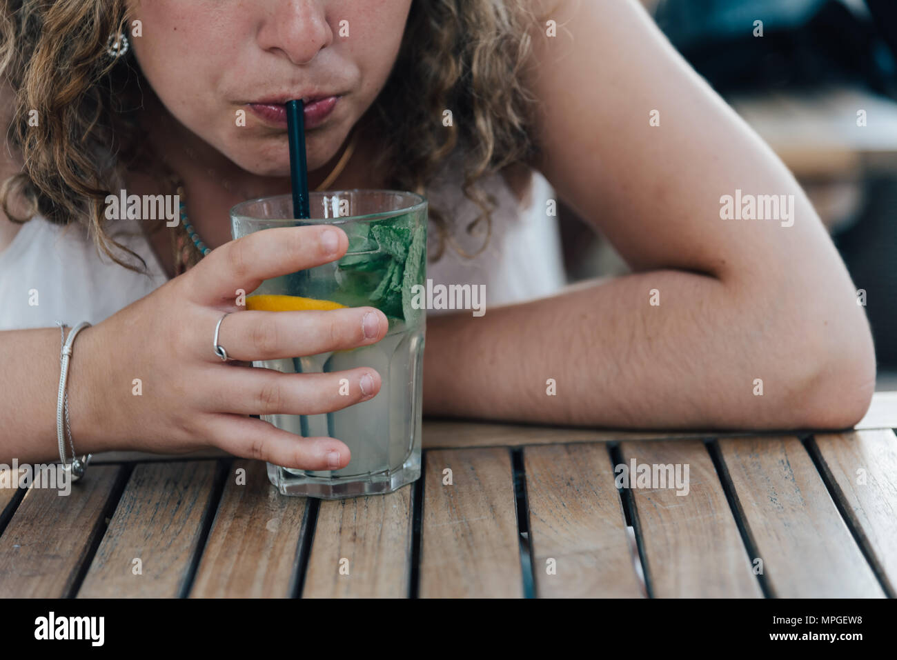Midsection of woman drinking lemonade glass on table Stock Photo - Alamy