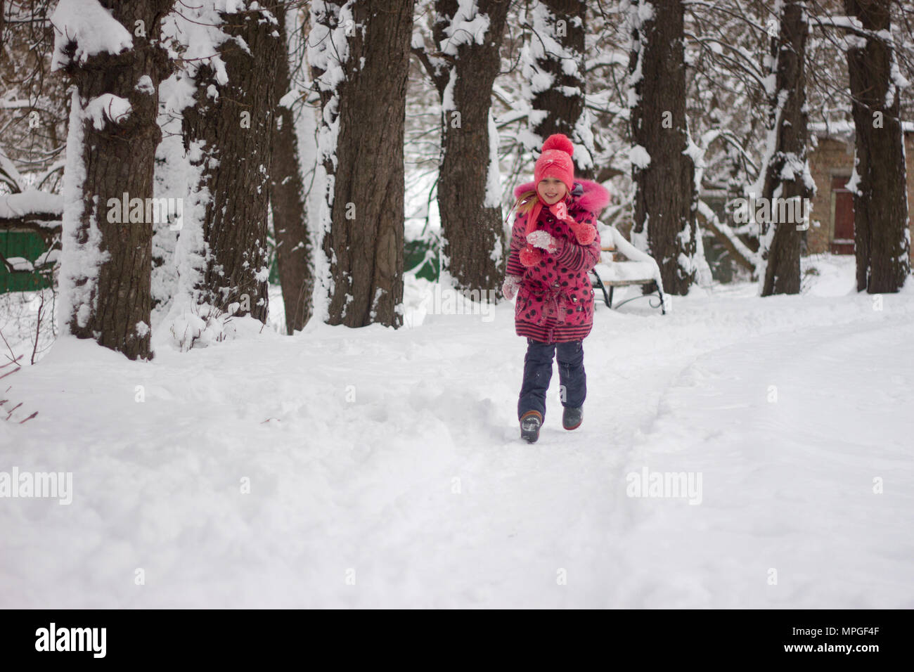 Little girl in winter pink hat in snow Stock Photo - Alamy