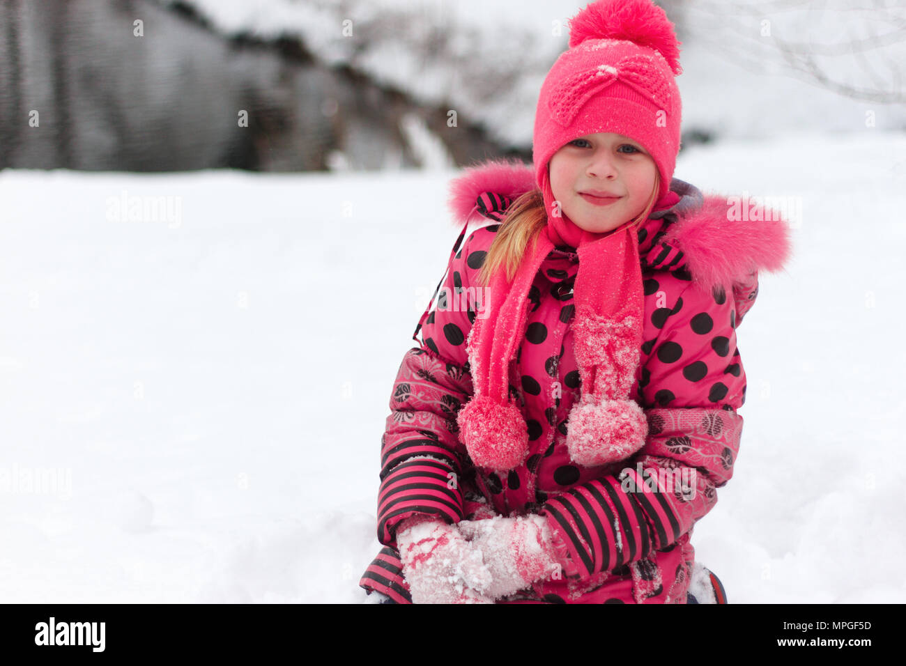 A little girl playing in a snow pile Stock Photo - Alamy