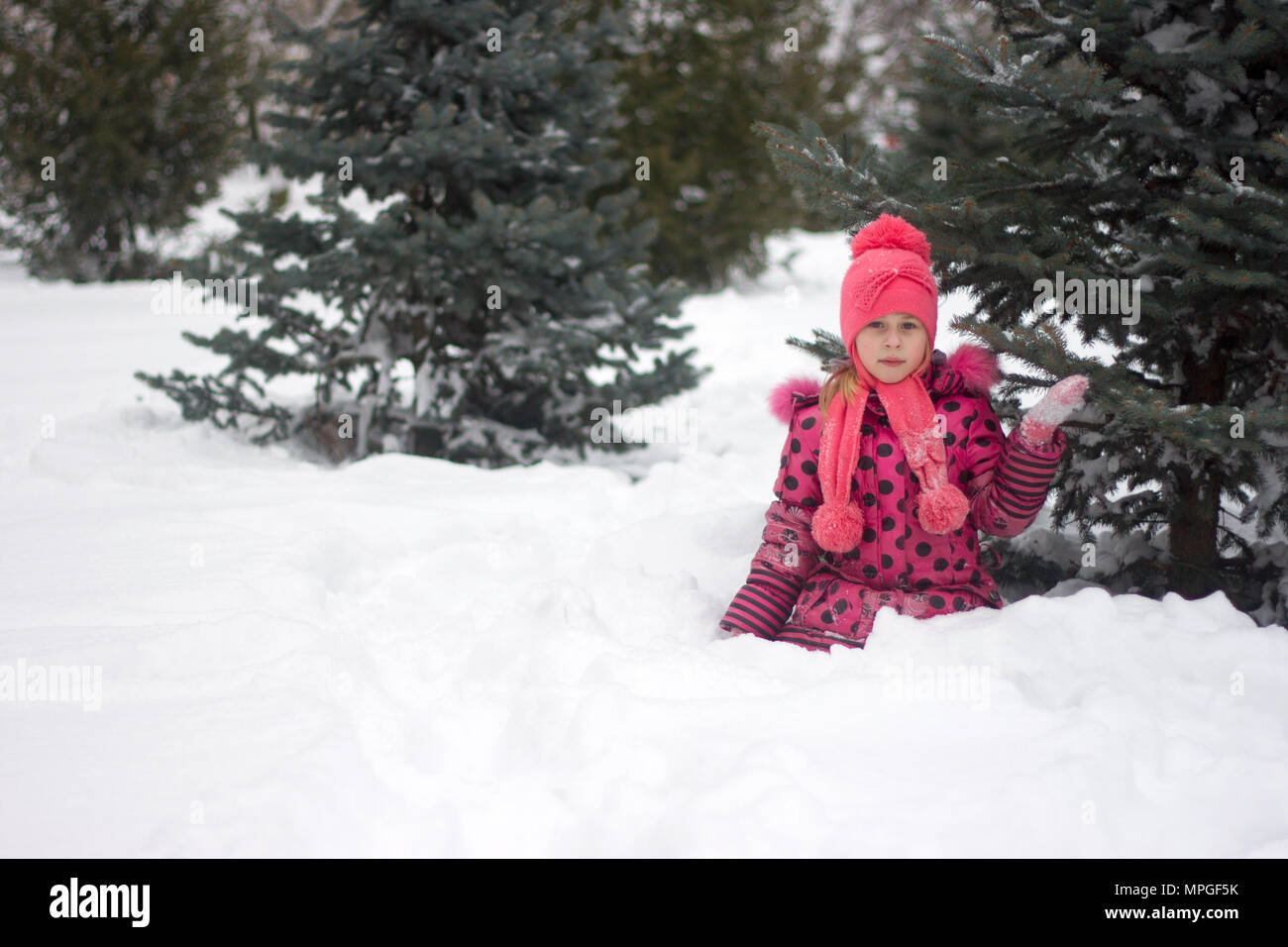 Little girl in winter pink hat in snow Stock Photo - Alamy