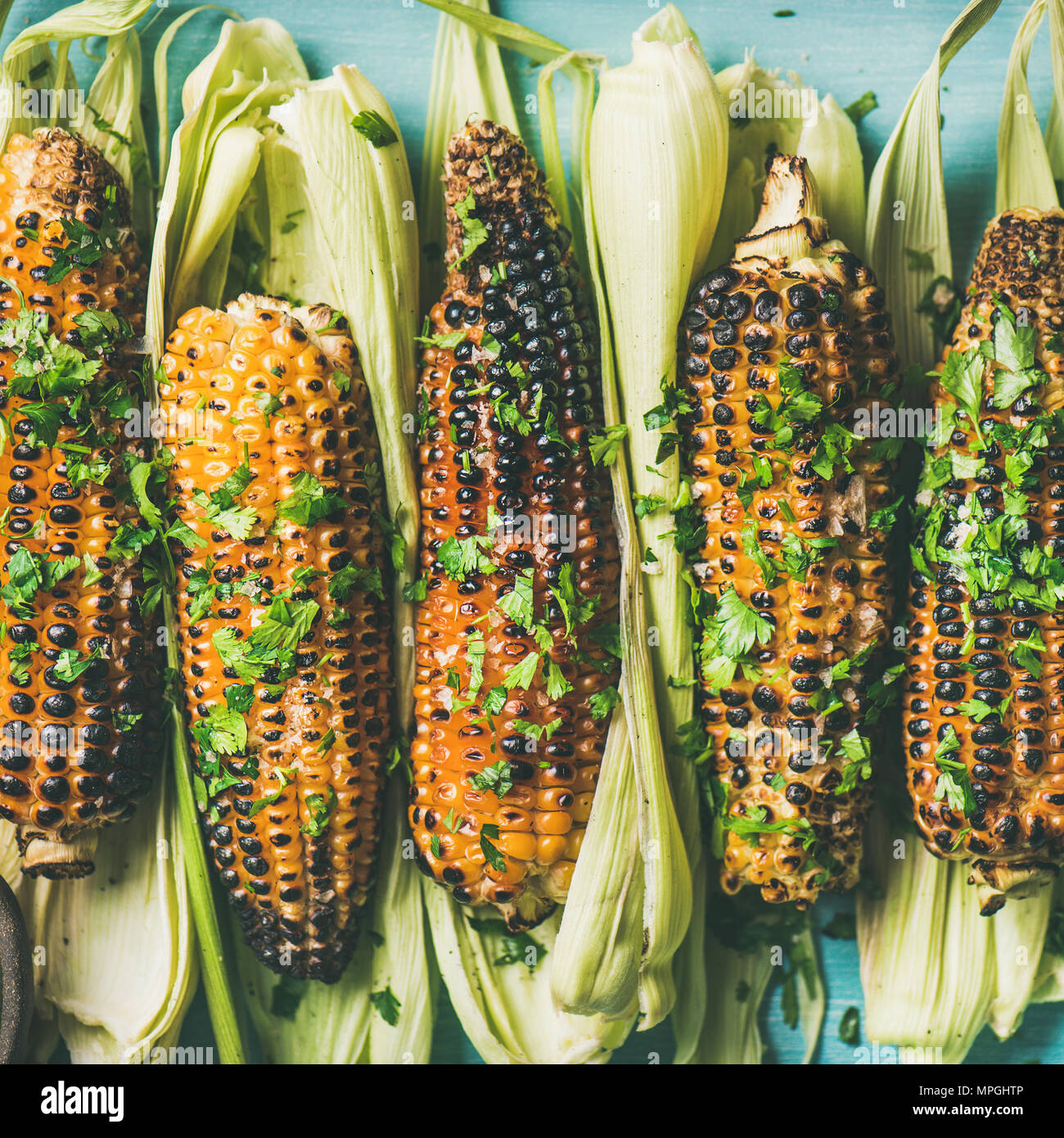 Flat-lay of grilled sweet corn with spices, square crop Stock Photo - Alamy