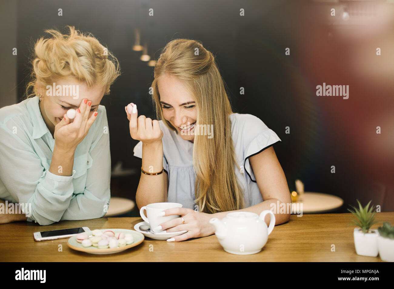 Two women gossiping at a meeting in a cafe Stock Photo - Alamy
