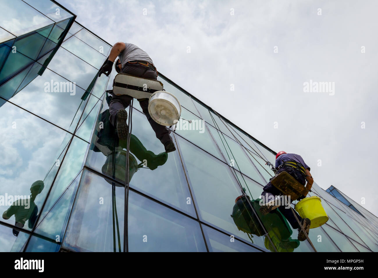 Industrial climbers are applying silicone to rubber juncture among ...