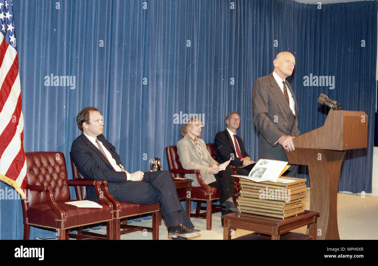 A MAN IS STANDING AT THE PODIUM GIVING A SPEECH WITH OTHER PEOPLE ...