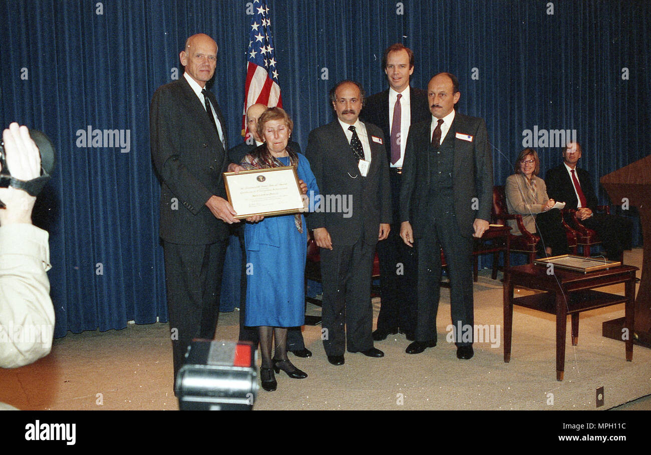 A GROUP MEN AND A WOMAN ON STAGE HOLDING A AWARD Stock Photo - Alamy