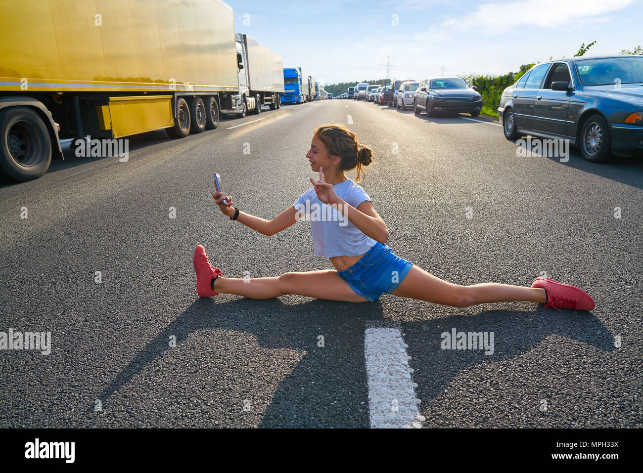 Split legs girl selfie photo in a traffic jam road having fun Stock ...