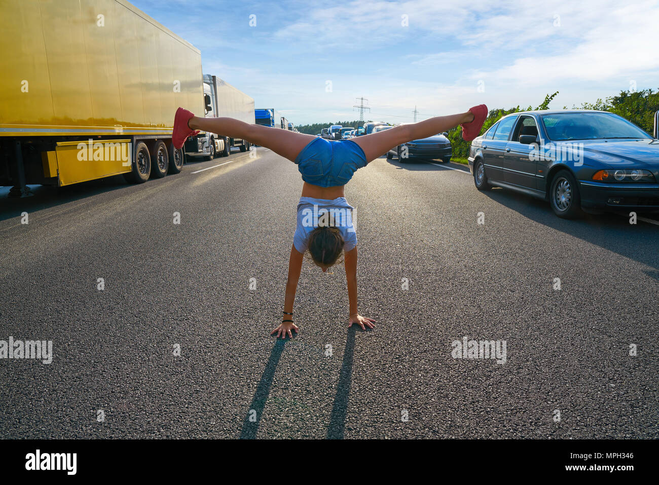 Acrobatic hand stand girl in a traffic jam road having fun Stock Photo ...