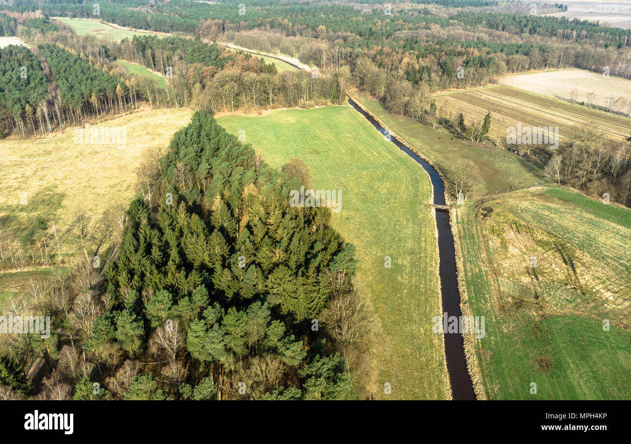 Aerial view of a stream flowing through meadows and fields with a small ...
