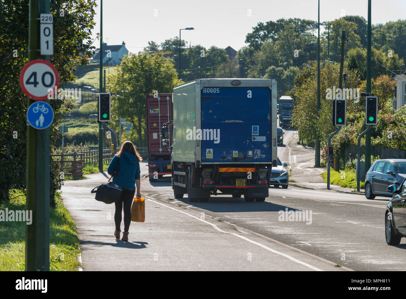A Woman Walks Along The Pavement Next To Vehicles Travelling Along The Arundel Bypass The A27