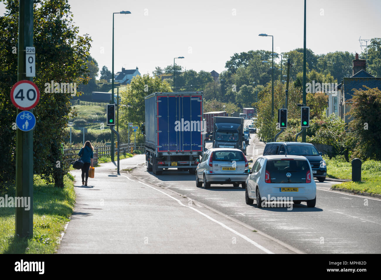 A Woman Walks Along The Pavement Next To Vehicles Travelling Along The Arundel Bypass The A27