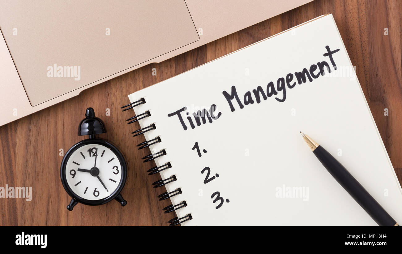 Time management concept with clock and list on notebook on wooden desk ...