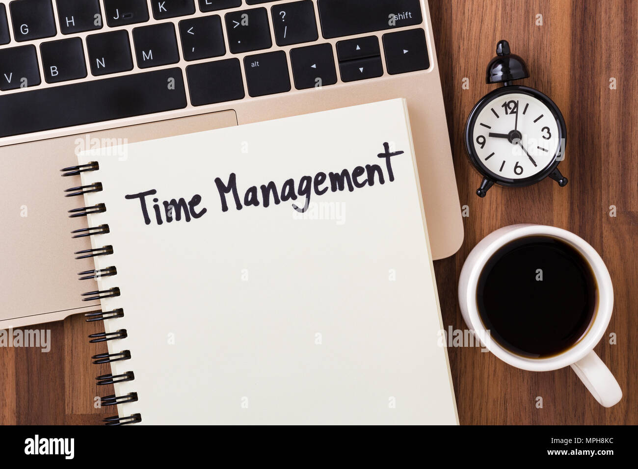 Time management concept with notebook and clock on wood desk from top ...