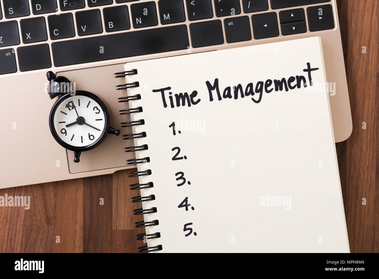 Time management concept with list on notebook and clock on computer ...