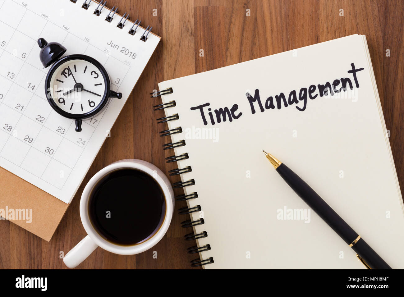 Time management concept with clock on calendar and notebook with pen ...