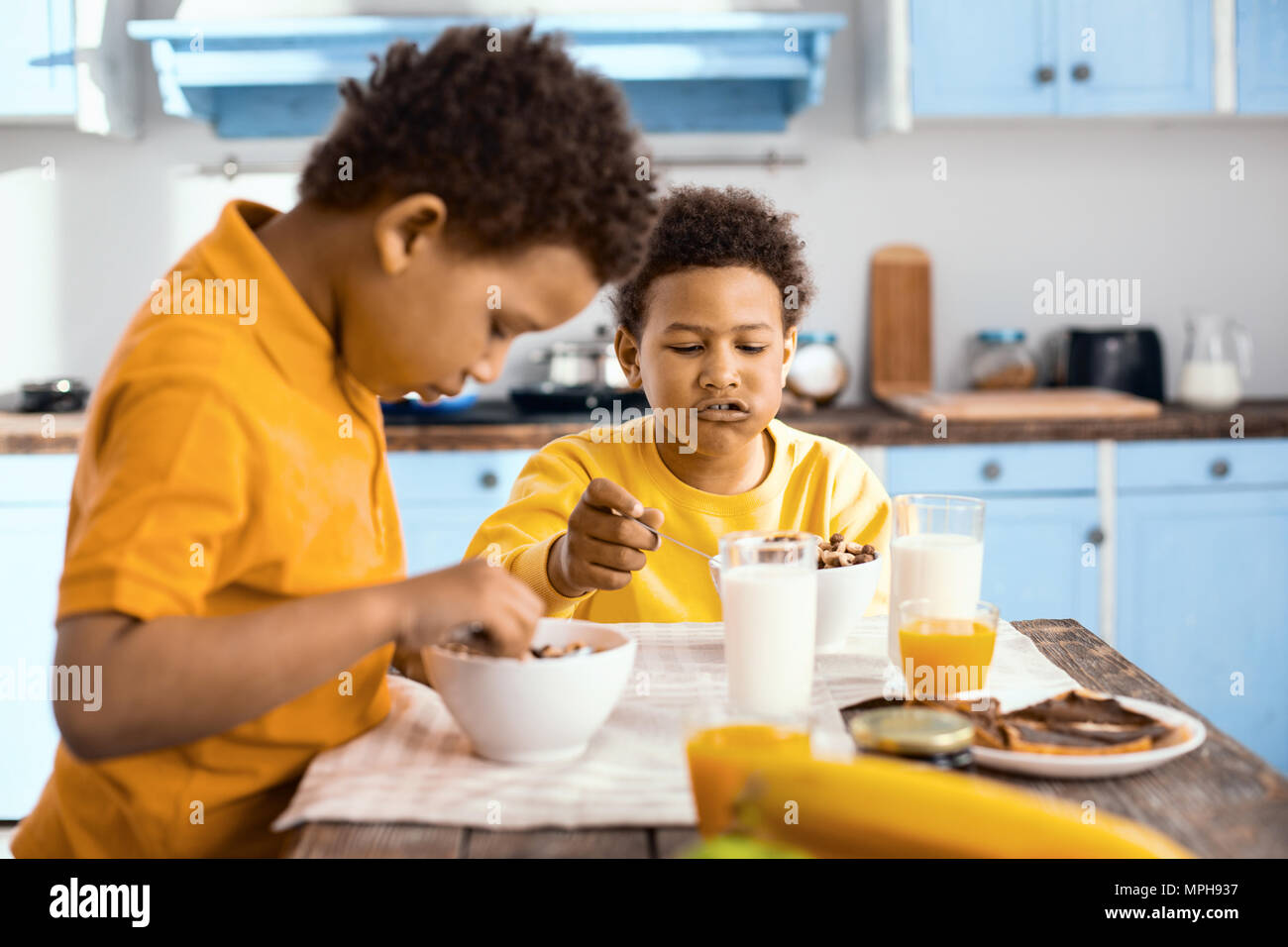 Curly-haired pre-teen boys eating cereals and talking Stock Photo - Alamy