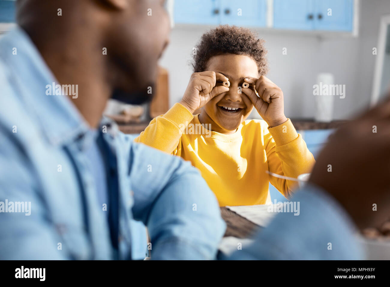 Joyful pre-teen boy goofing around during breakfast Stock Photo - Alamy